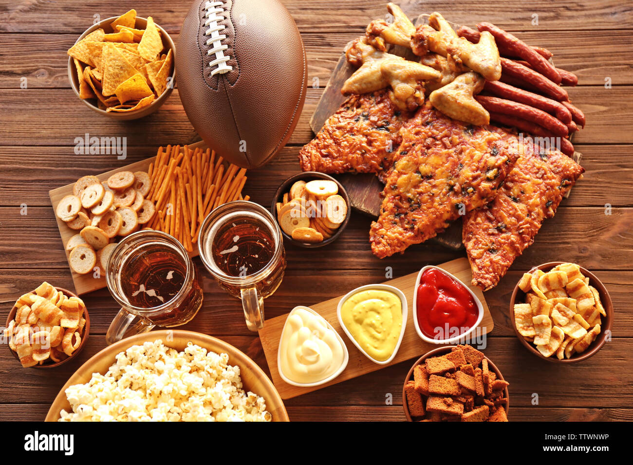 Table full of tasty snacks and beer prepared for watching rugby on TV ...