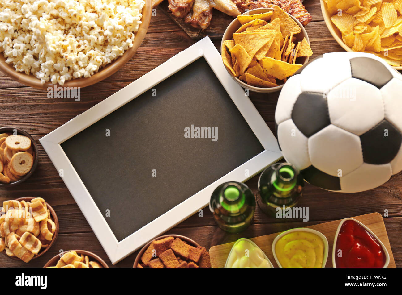 Ball, frame, beer and tasty snacks on wooden table Stock Photo - Alamy