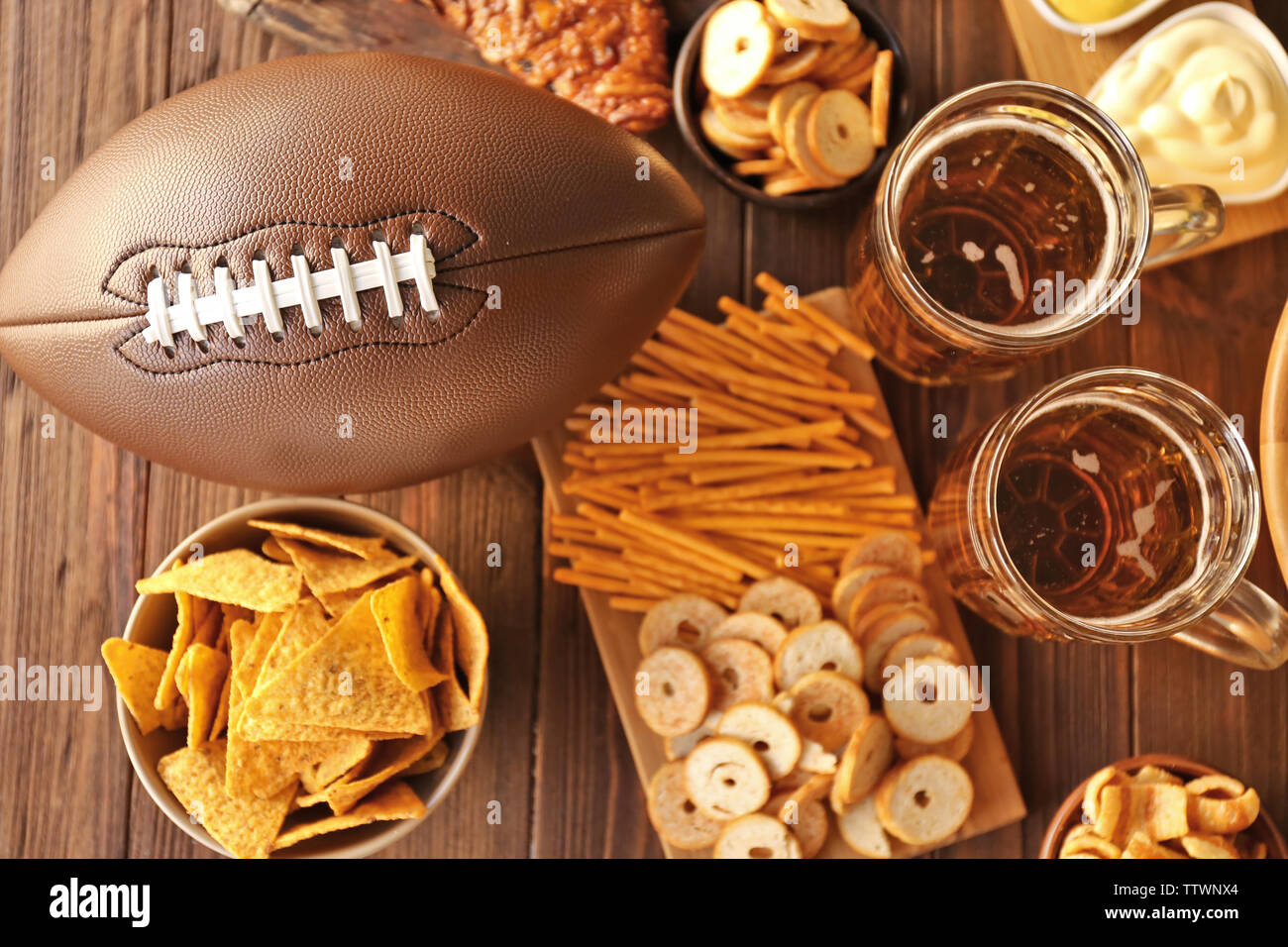 Table full of tasty snacks and beer prepared for watching rugby on TV ...
