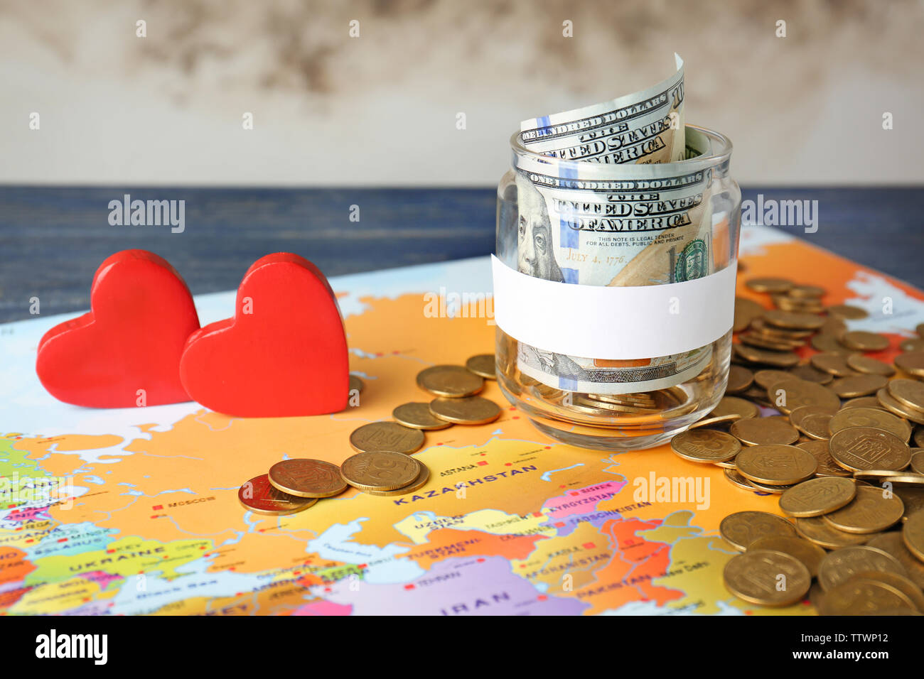 Glass jar with money on world map Stock Photo - Alamy