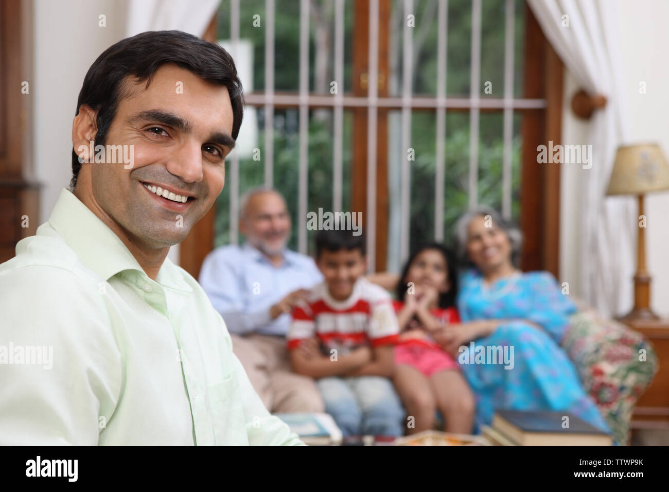 Portrait of an Indian man with his family in the background Stock Photo ...