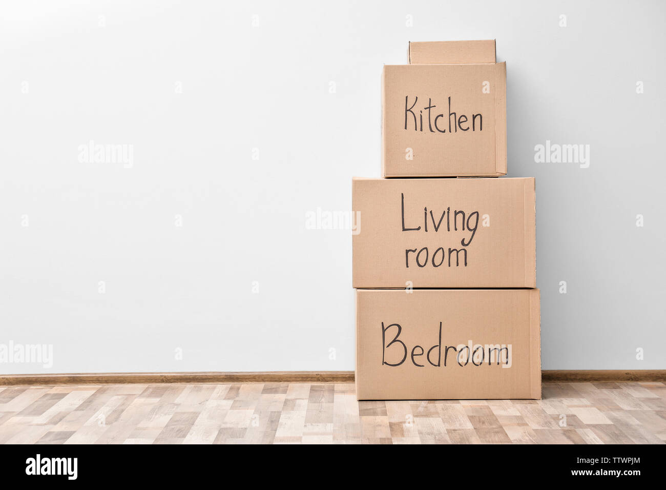 Empty room with moving boxes on wall background Stock Photo - Alamy