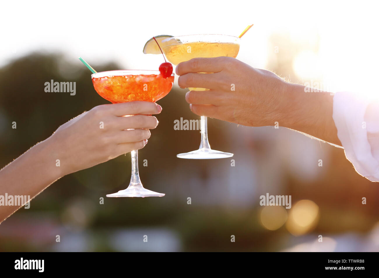 Male And Female Hands Holding Glasses With Margarita Cocktail On