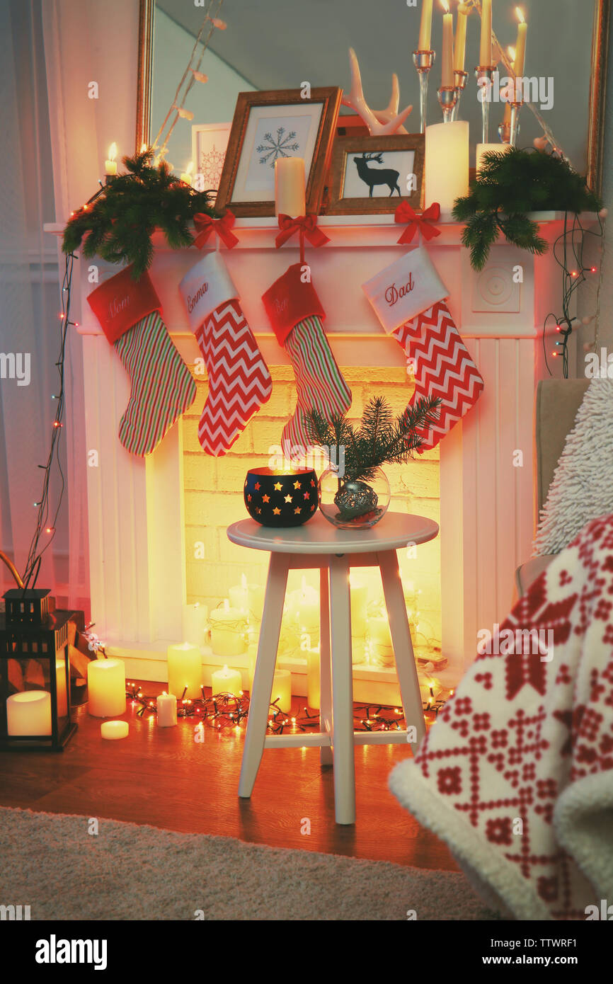 Stool with Christmas decor near fireplace Stock Photo - Alamy