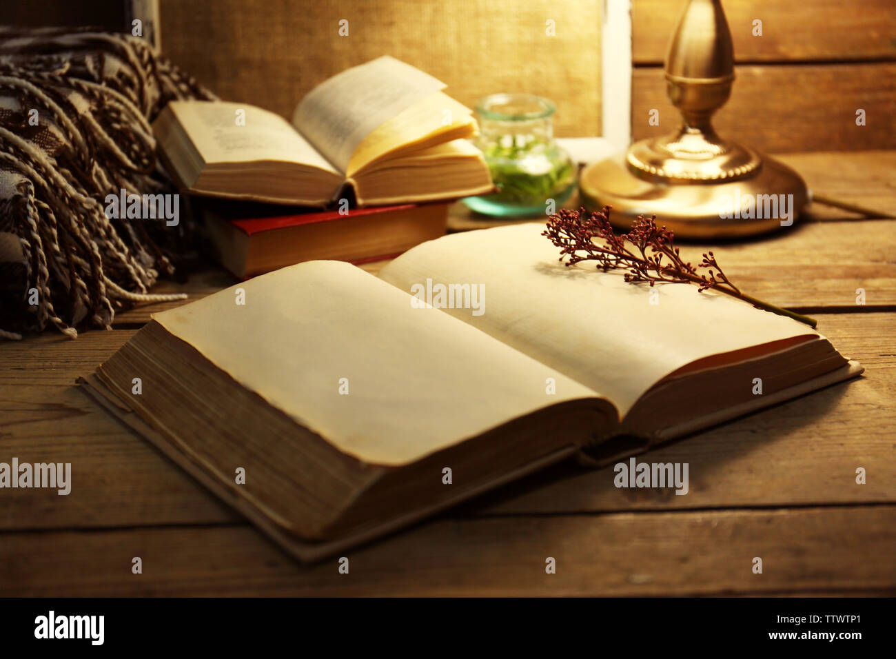 Old open book on wooden table at night Stock Photo - Alamy