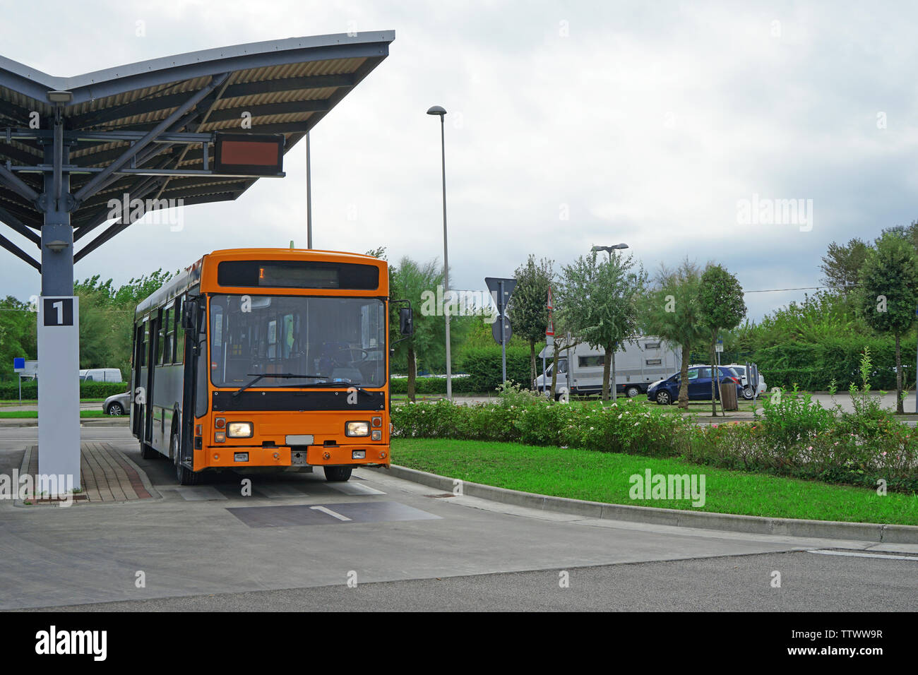 Bus station with orange bus Stock Photo - Alamy