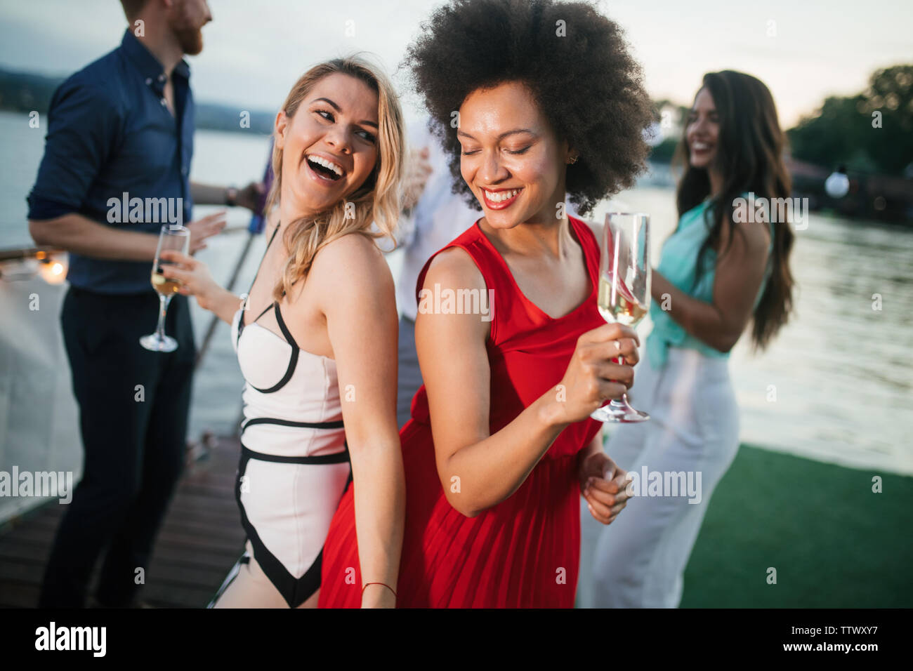 Group of friends drinking, chatting and having a fun at outdoor party ...