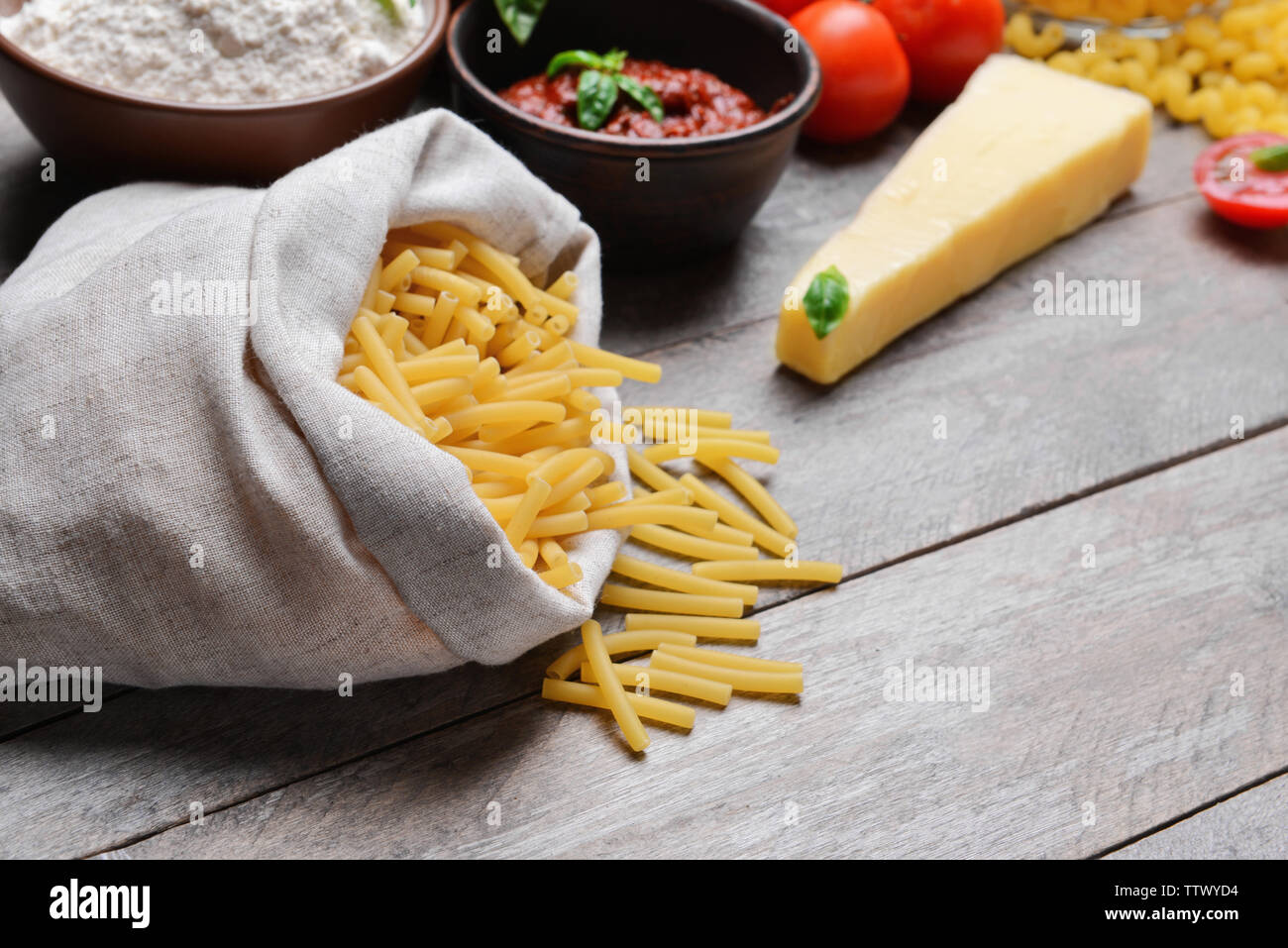 Dry pasta in sack on wooden background Stock Photo - Alamy