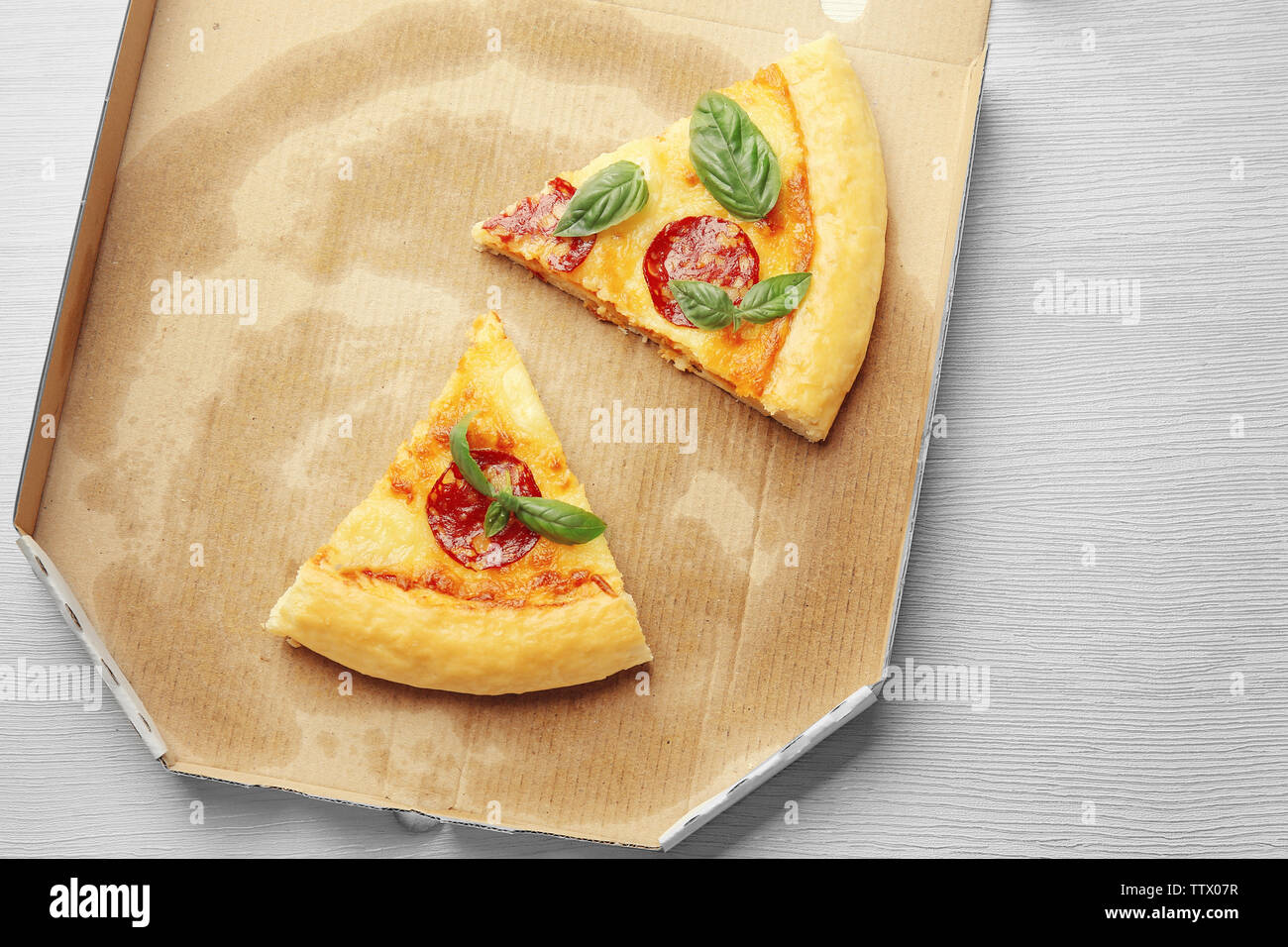 Slices of pepperoni pizza on cardboard Stock Photo - Alamy