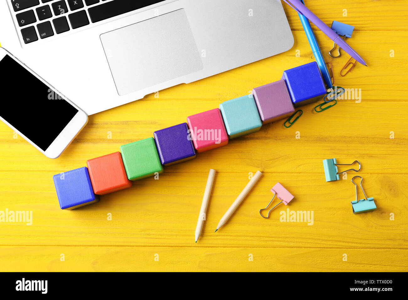 Laptop and wooden cubes on color background Stock Photo - Alamy