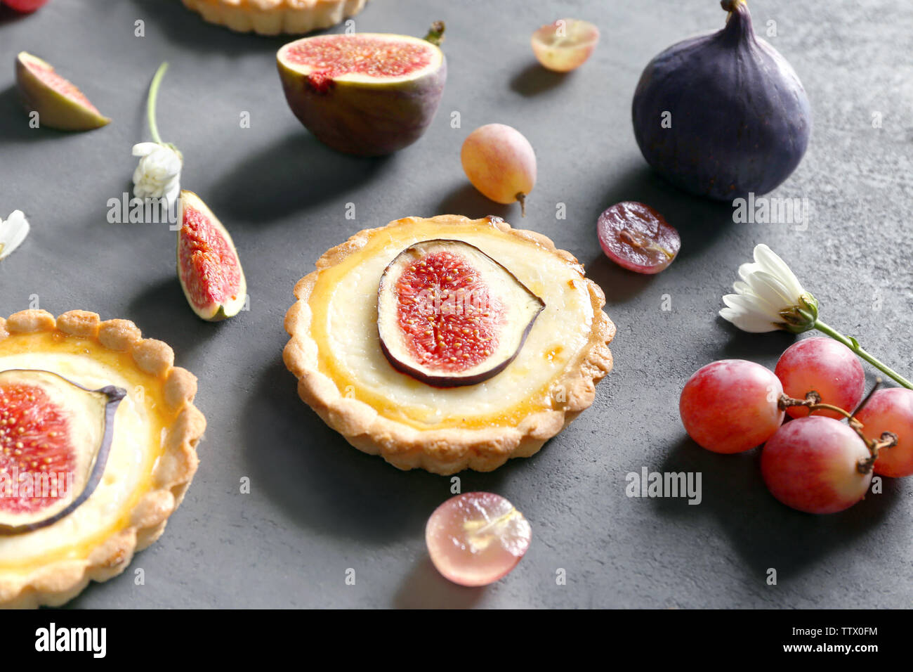 Tasty fig cakes with fresh grapes on grey background Stock Photo - Alamy
