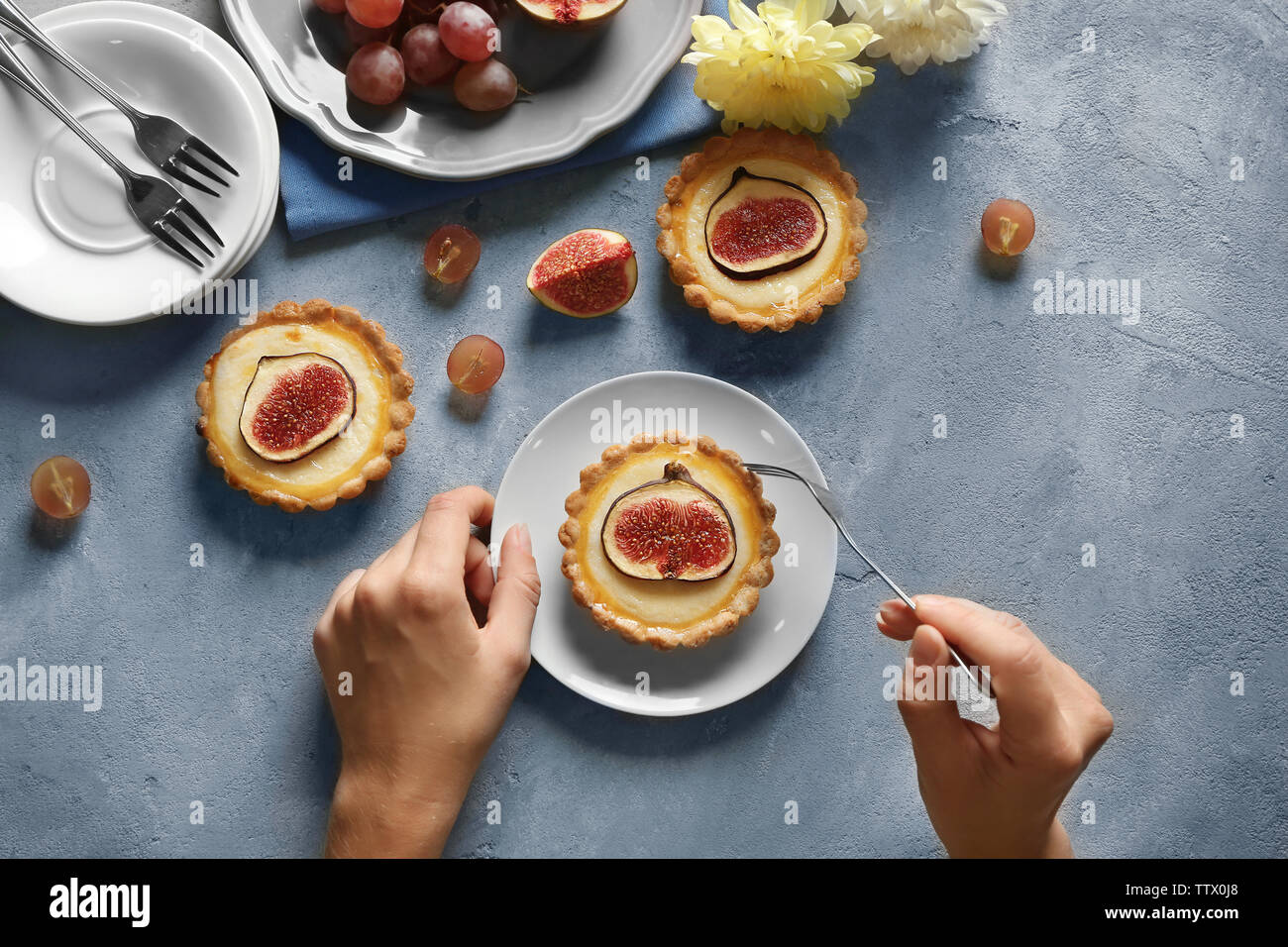 Woman with fork and knife ready to eat fig cake, top view Stock Photo ...