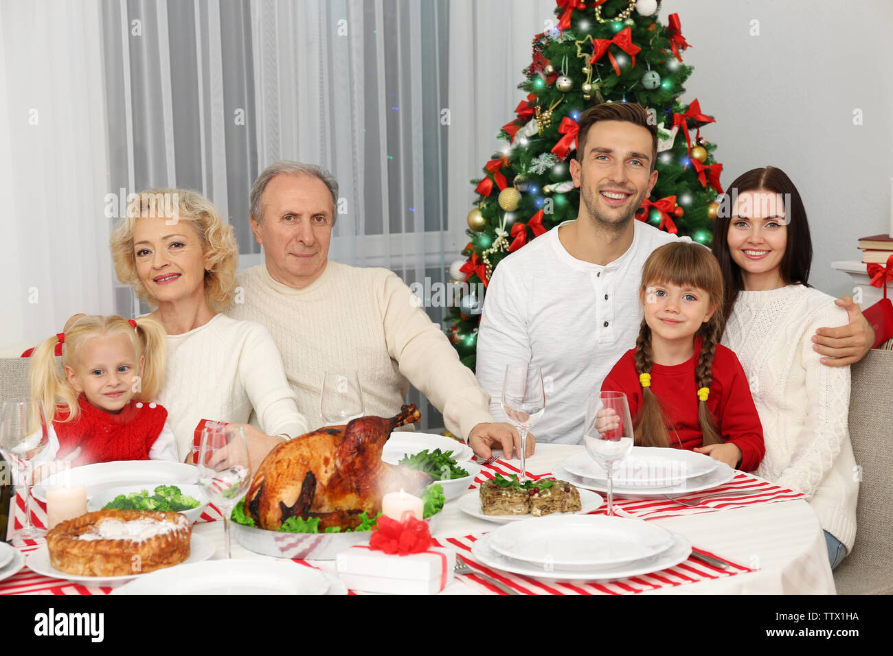Happy family having Christmas dinner in living room Stock Photo - Alamy