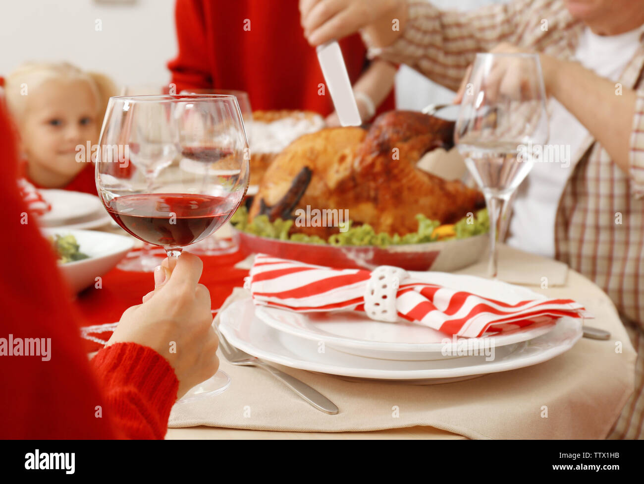 Close up view of female hand with glass of red wine on blurred ...