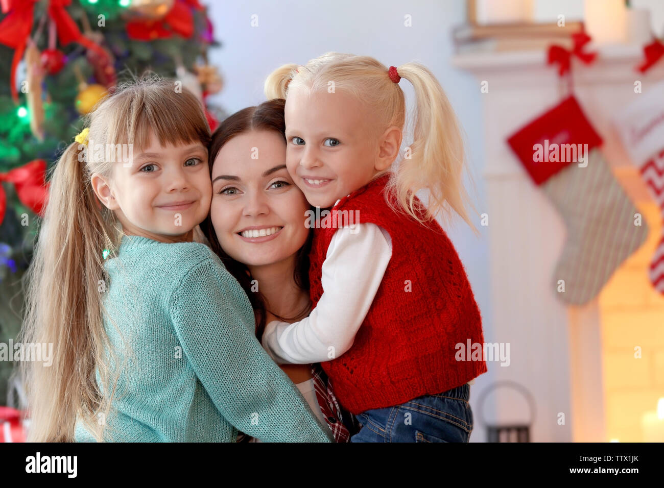 Portrait of beautiful young woman with two daughters on blurred ...