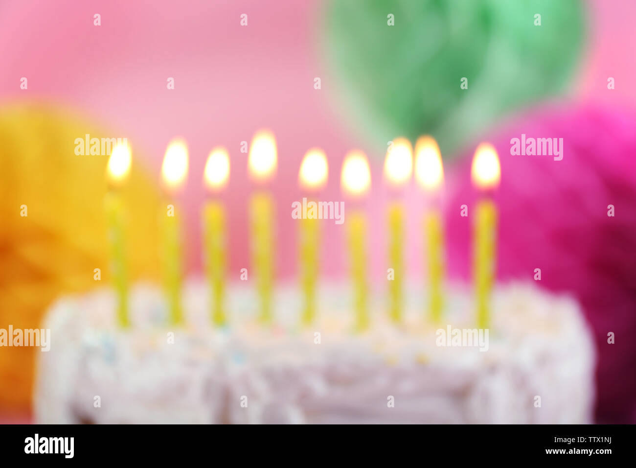 Blurred Birthday cake with candles on color background Stock Photo - Alamy