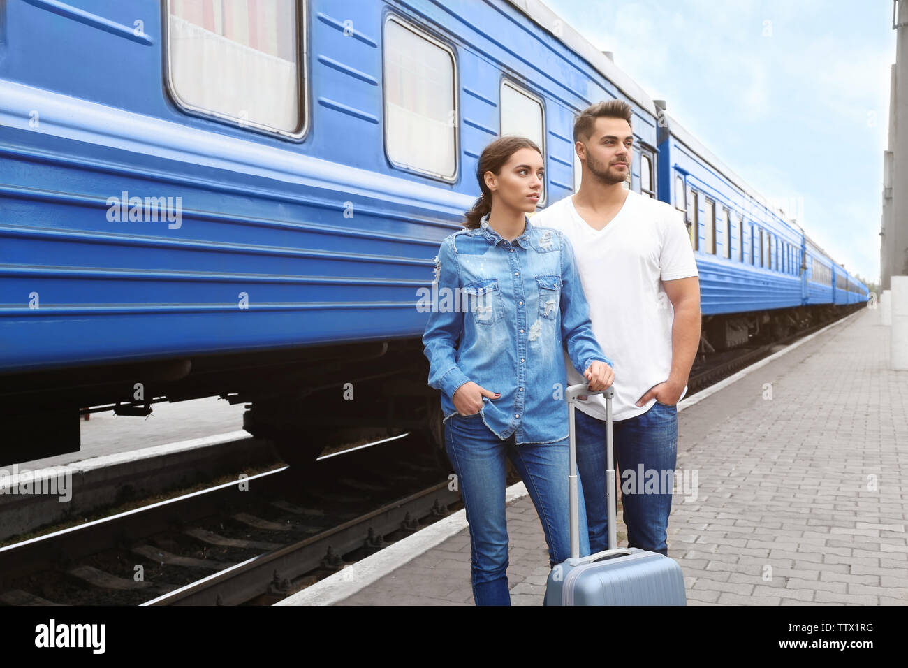 Young couple standing on railway platform near train Stock Photo - Alamy