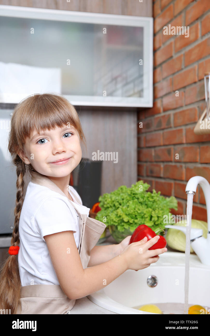 Small girl washing vegetables in kitchen Stock Photo - Alamy