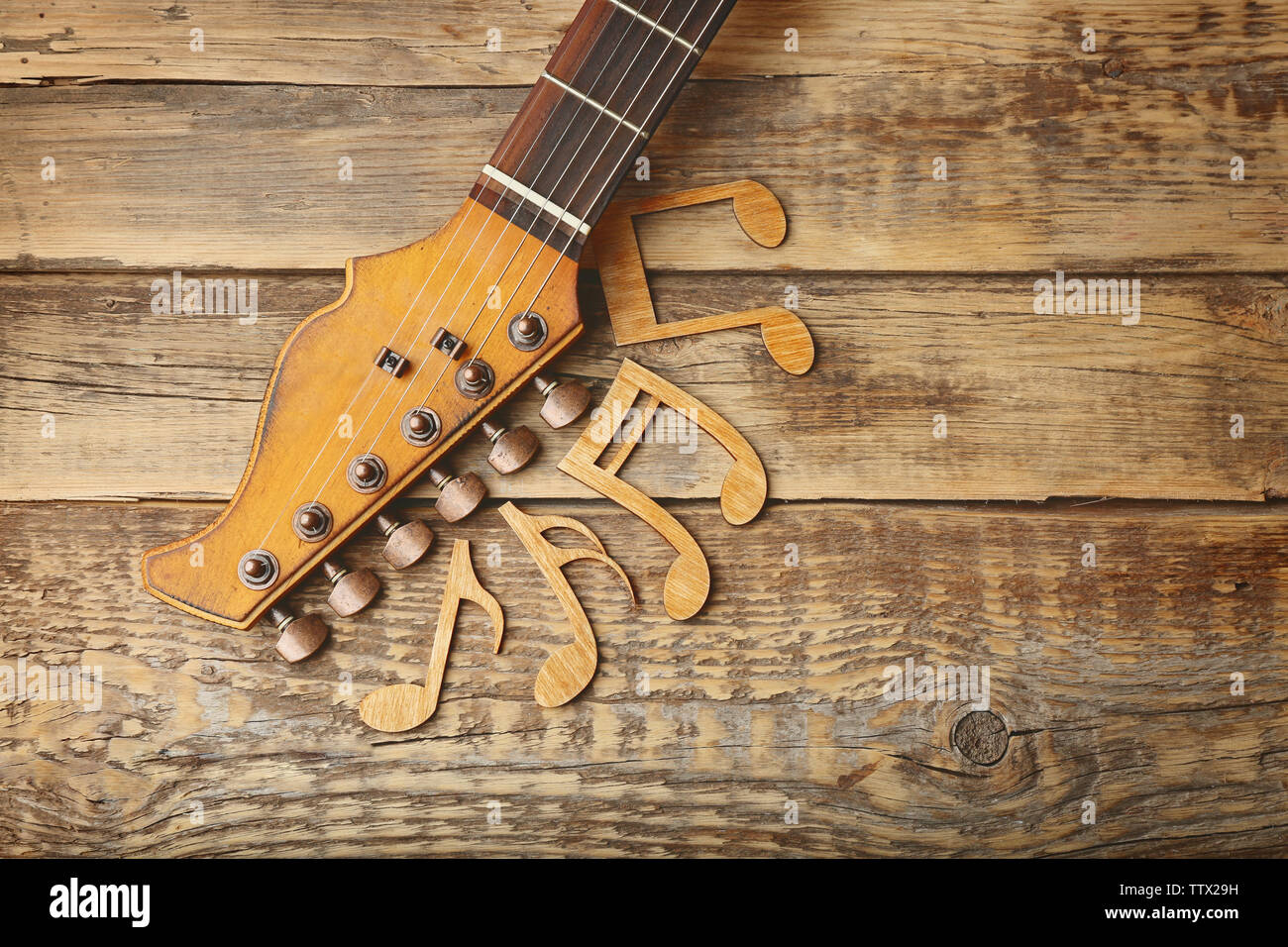 Guitar neck and music notes on wooden background Stock Photo - Alamy
