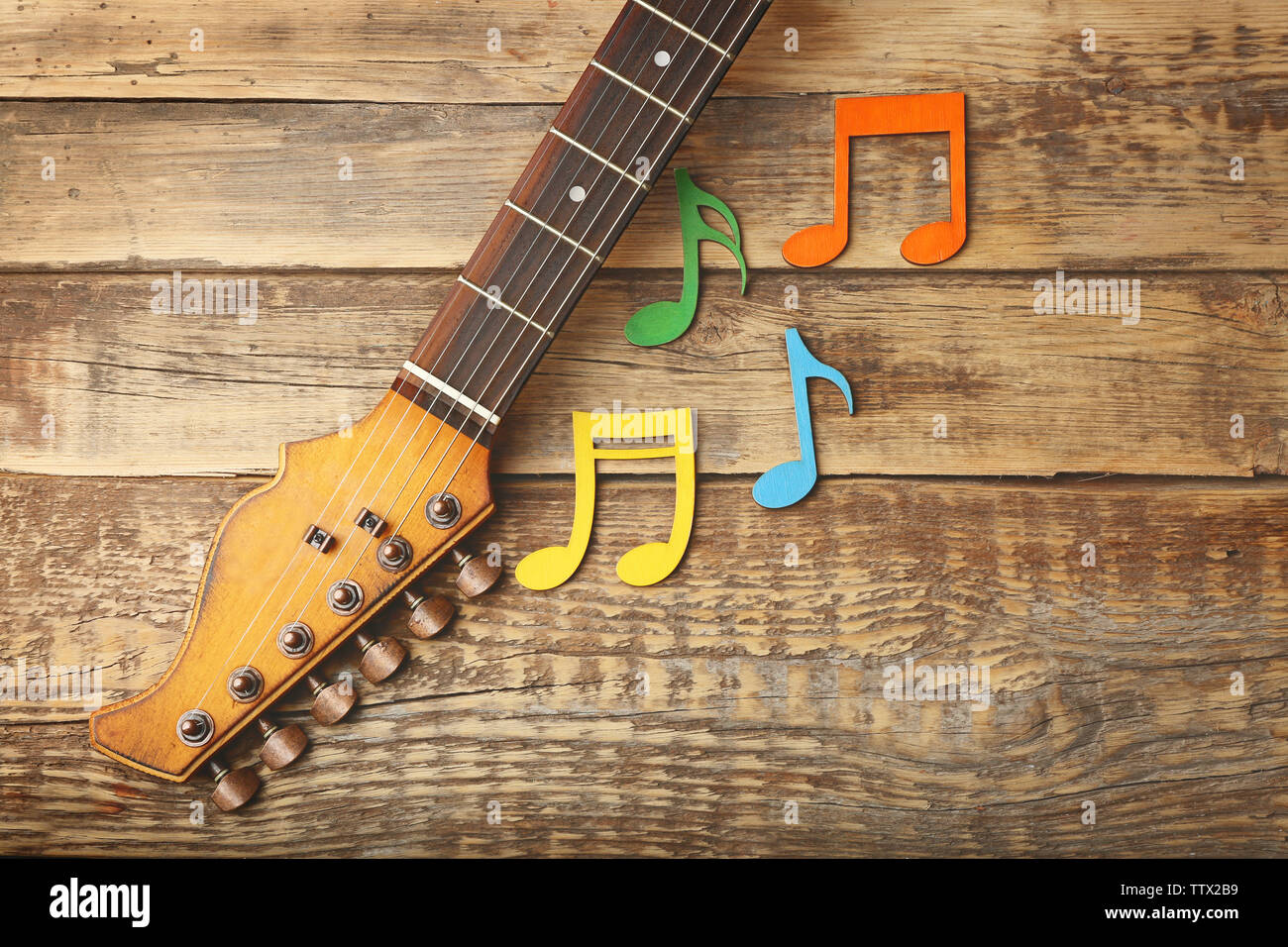 Guitar neck and music notes on wooden background Stock Photo - Alamy