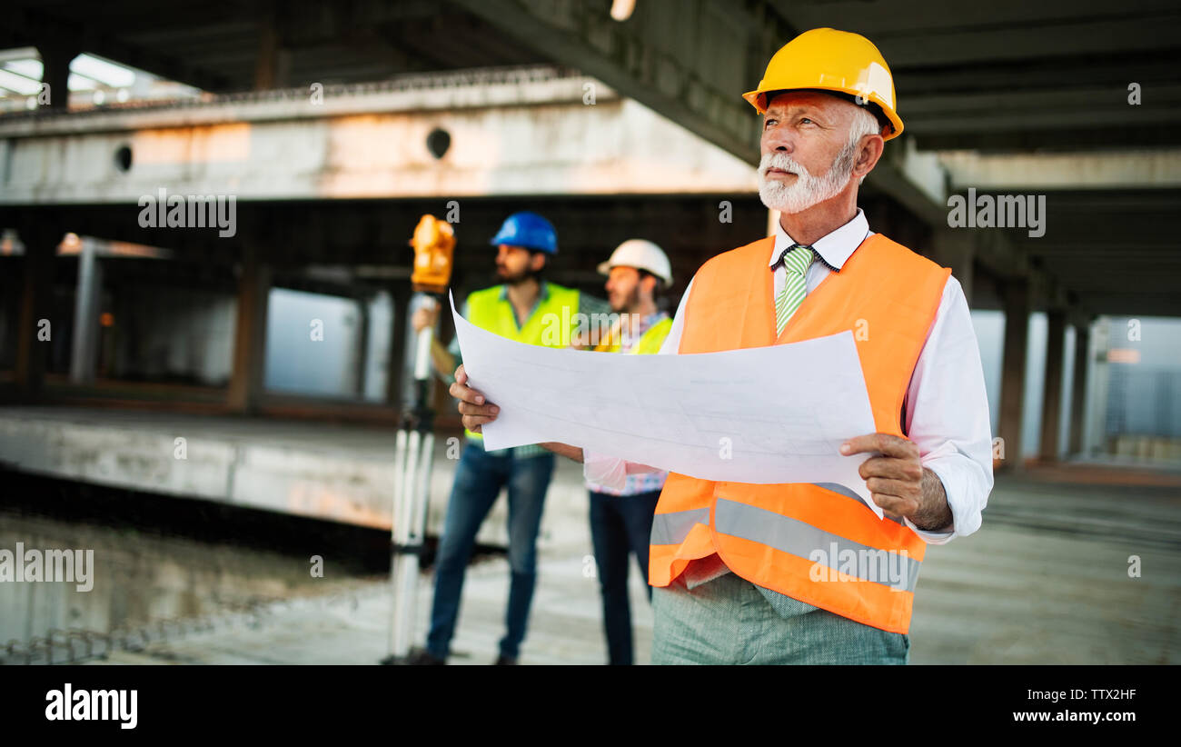 Engineer and construction site manager dealing with blueprints and ...