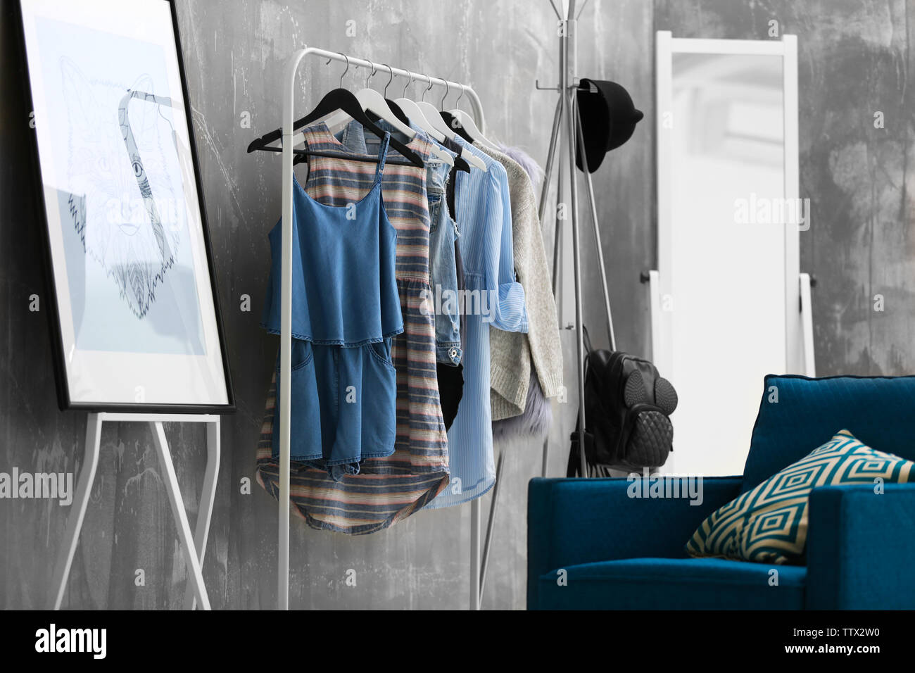 Fashionable clothes hanging on rack at modern dressing room Stock Photo ...