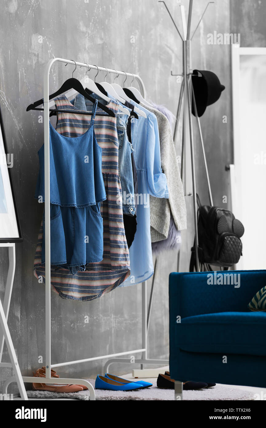 Fashionable clothes hanging on rack at modern dressing room Stock Photo ...