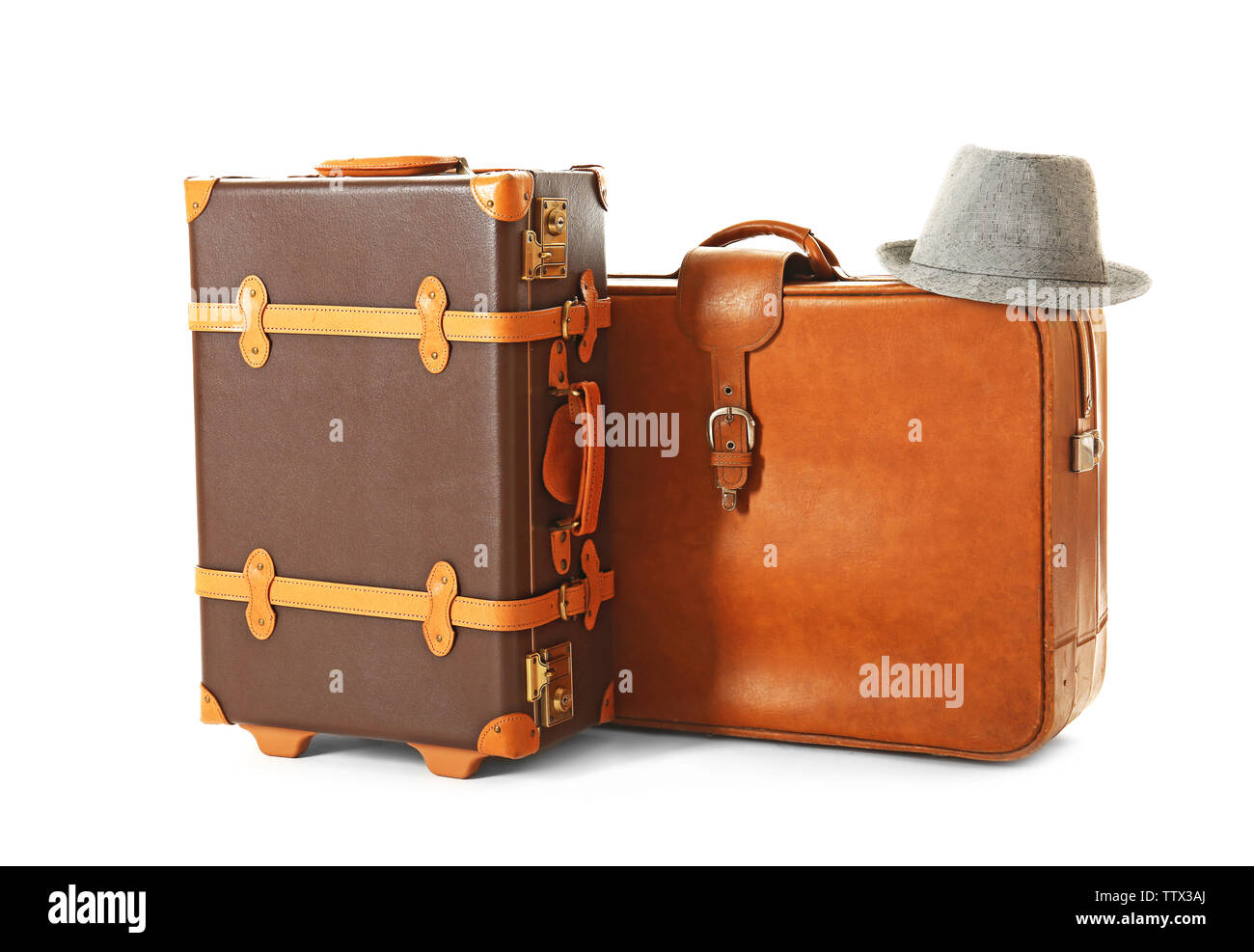 Modern suitcases and hat isolated on white Stock Photo - Alamy