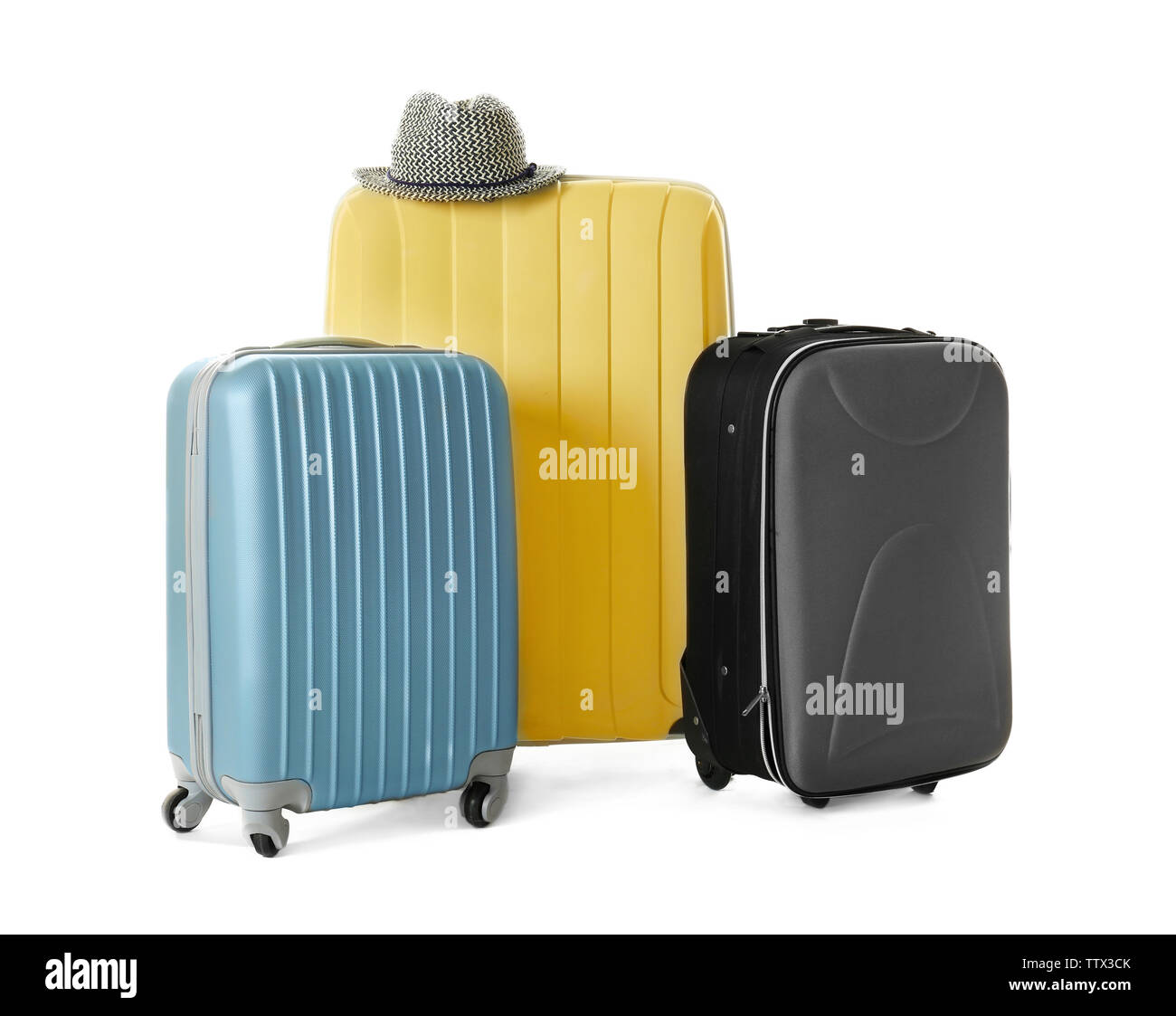 Modern suitcases and hat isolated on white Stock Photo - Alamy