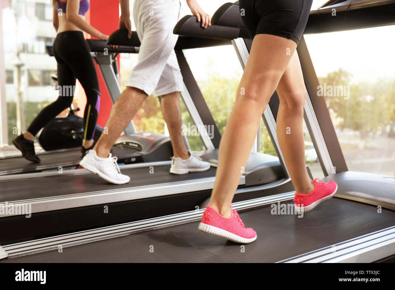Young people running on treadmills in gym, close up view Stock Photo ...