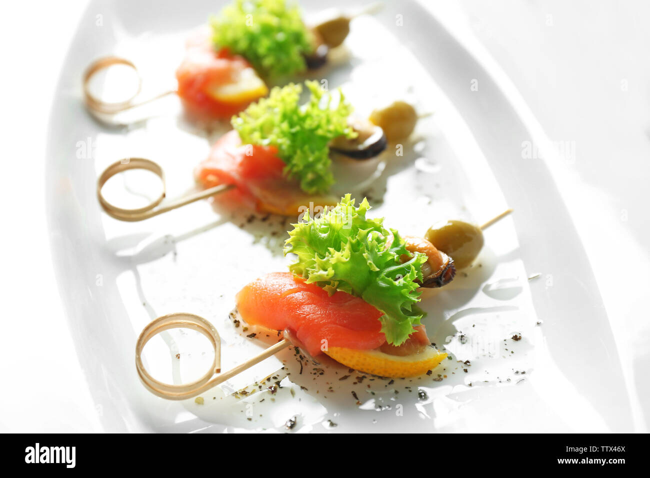 Set of delicious canapes on white plate closeup Stock Photo - Alamy