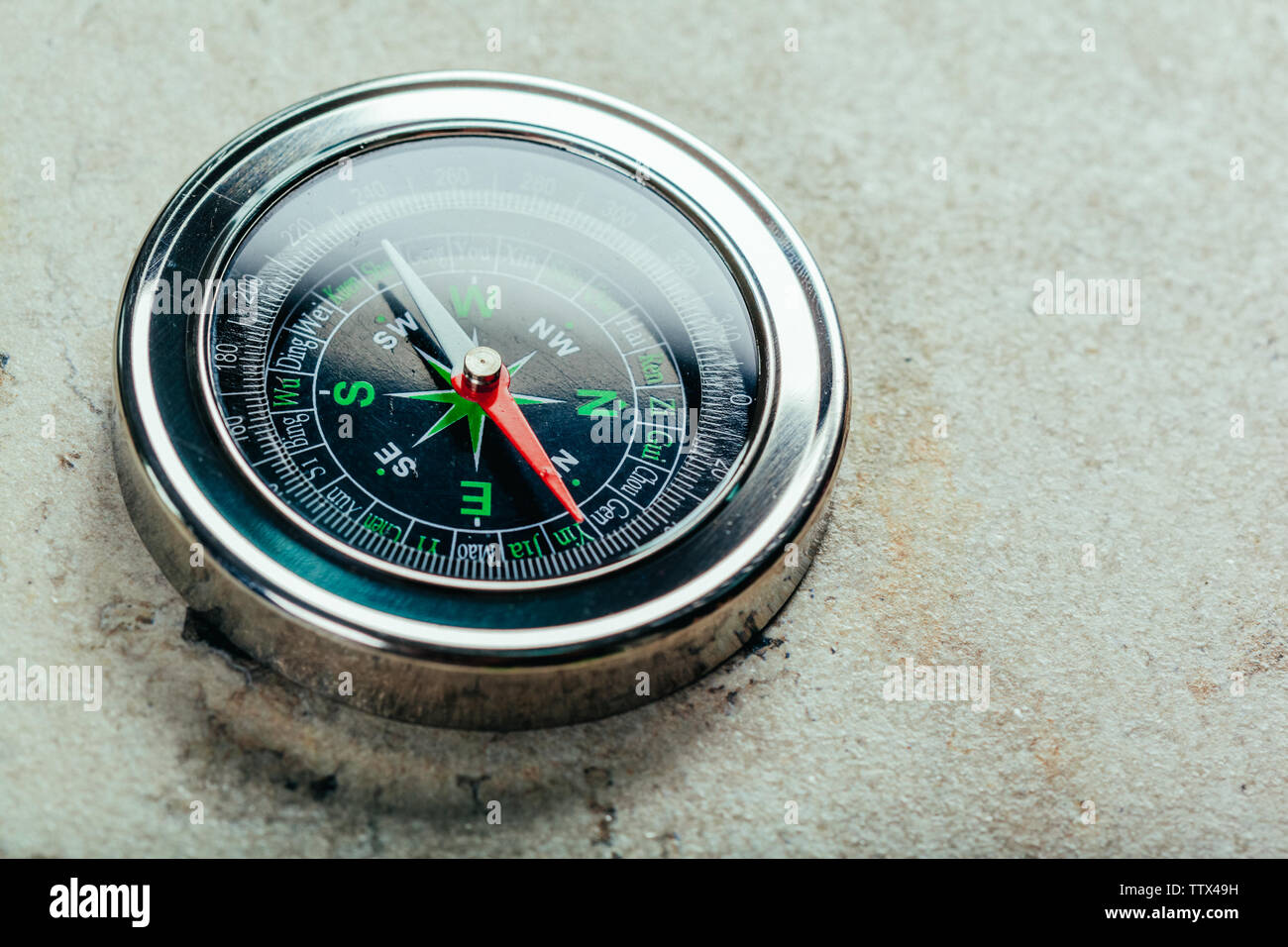 Compass on a gray gradient background Stock Photo - Alamy