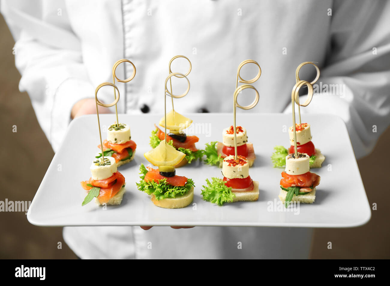 Chef holding plate with assorted canapes closeup Stock Photo - Alamy