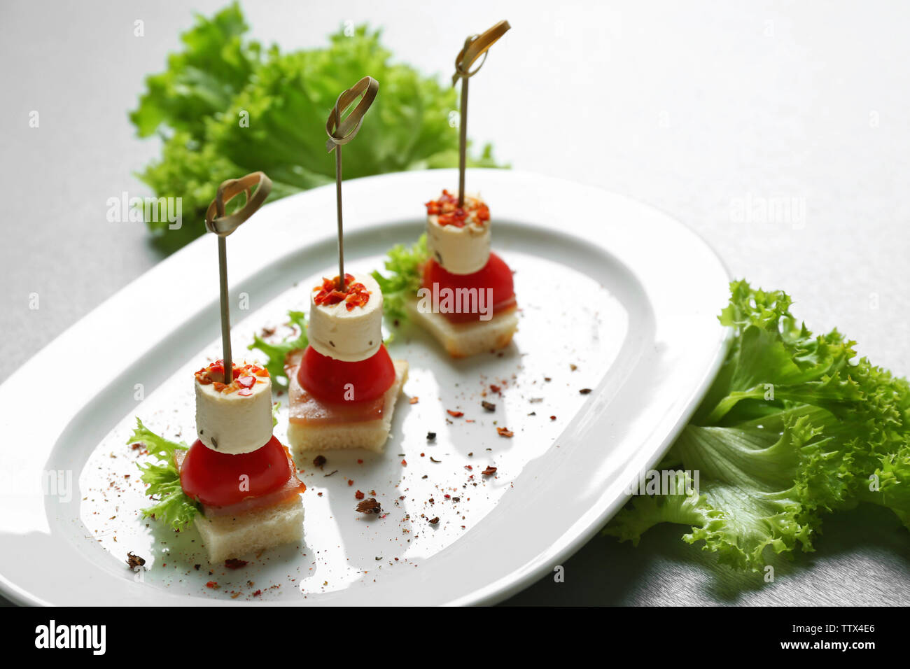 Set of delicious canapes on white plate closeup Stock Photo - Alamy