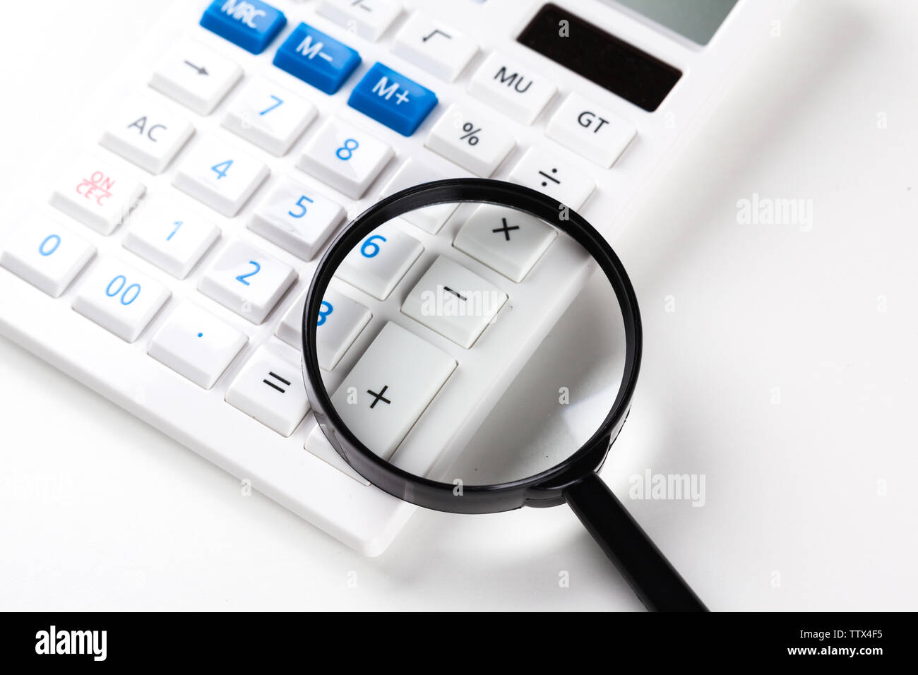 Calculator with a magnifying glass on a white background Stock Photo ...