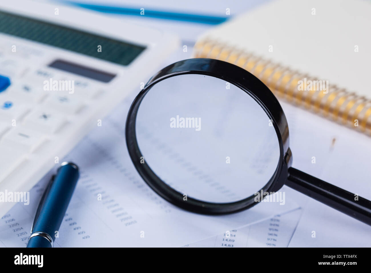 work with a magnifying glass, a calculator and papers Stock Photo - Alamy