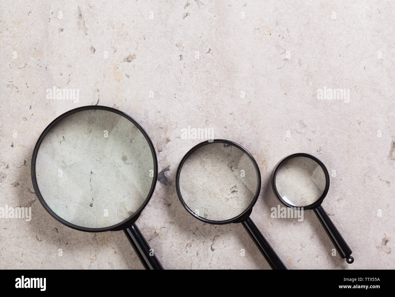 Magnifying glass with empty stone background Stock Photo - Alamy