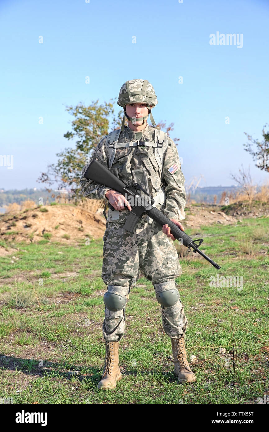 Soldier with rifle standing at military firing range near river Stock ...