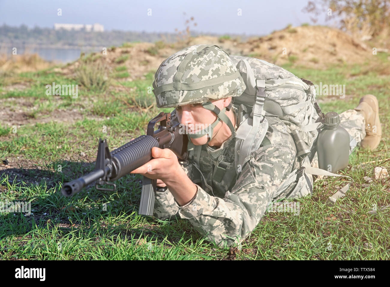 Soldier in camouflage taking aim at military firing range, close up ...