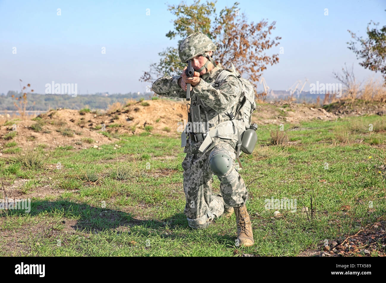Soldier in camouflage taking aim at military firing range Stock Photo ...