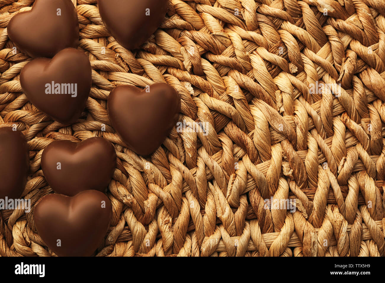 Chocolate hearts on wicker mat background Stock Photo - Alamy