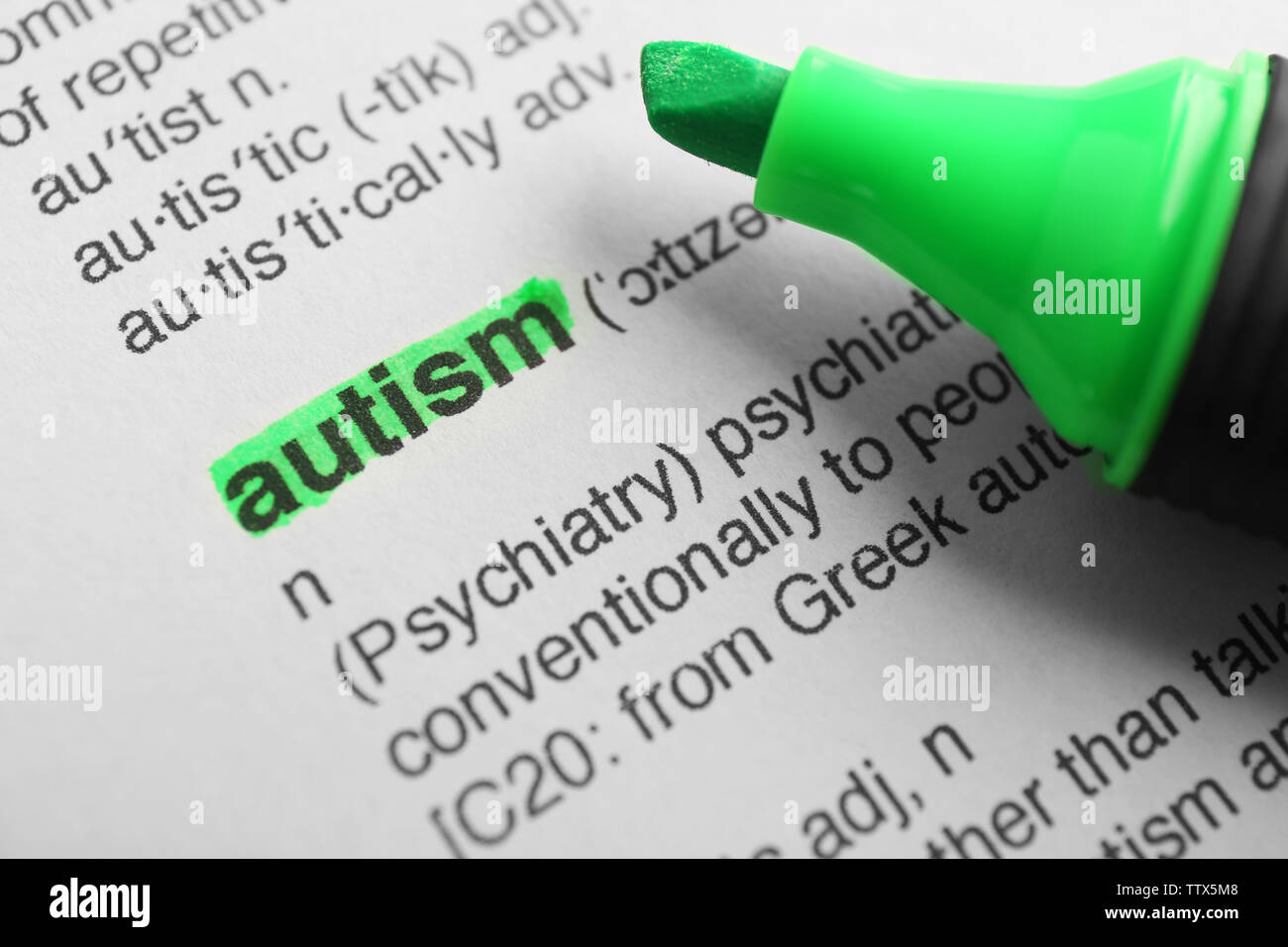 Highlighted in green word AUTISM on page of dictionary Stock Photo - Alamy