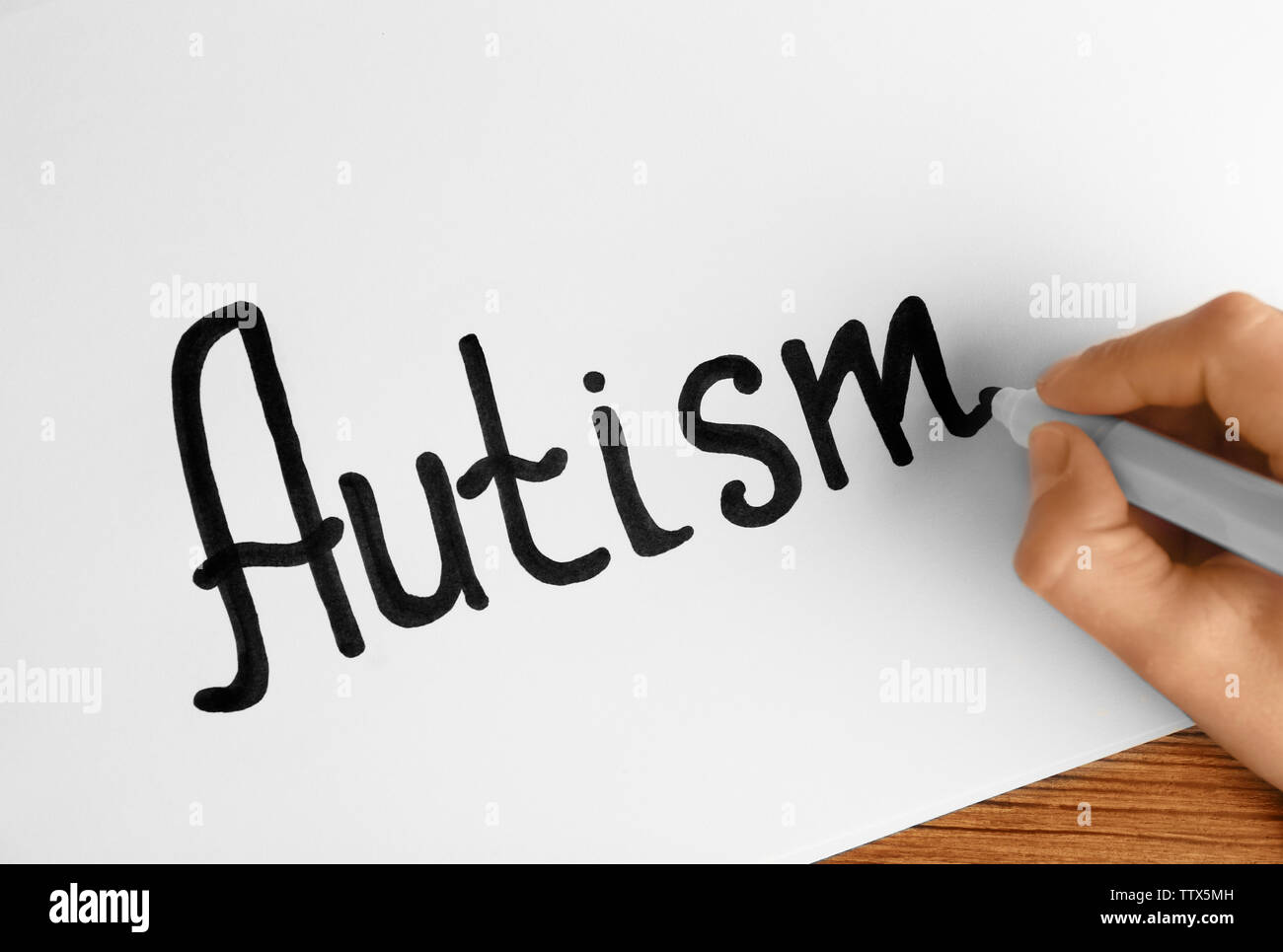 Human hand writing word AUTISM on paper, closeup Stock Photo - Alamy