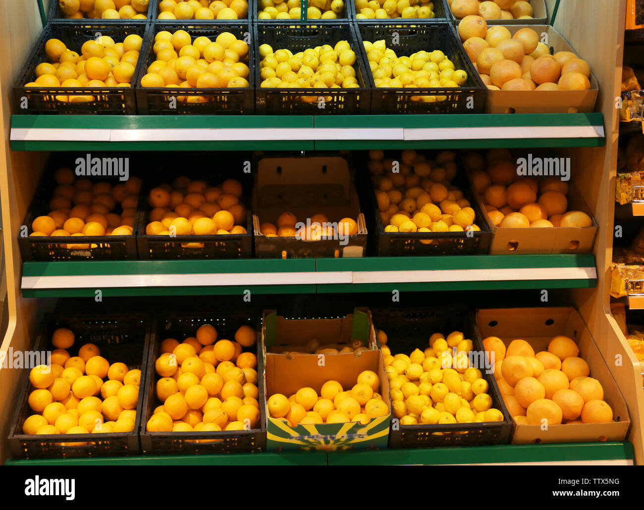 Boxes with fresh citrus fruits in supermarket Stock Photo - Alamy