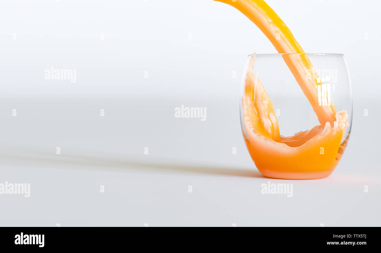 Pouring juices into transparent glass Stock Photo - Alamy