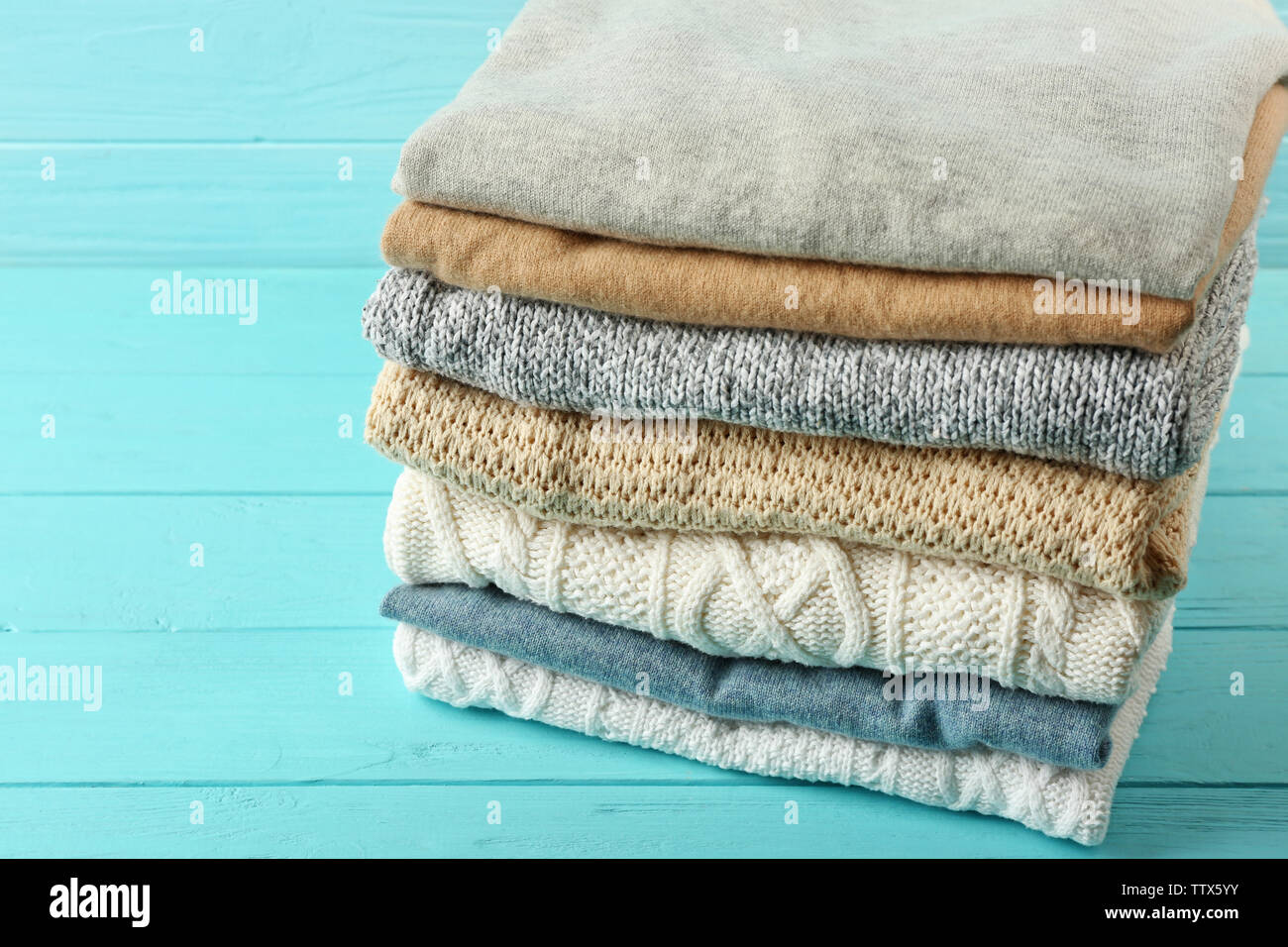 Stack of folded clothes on wooden background Stock Photo - Alamy