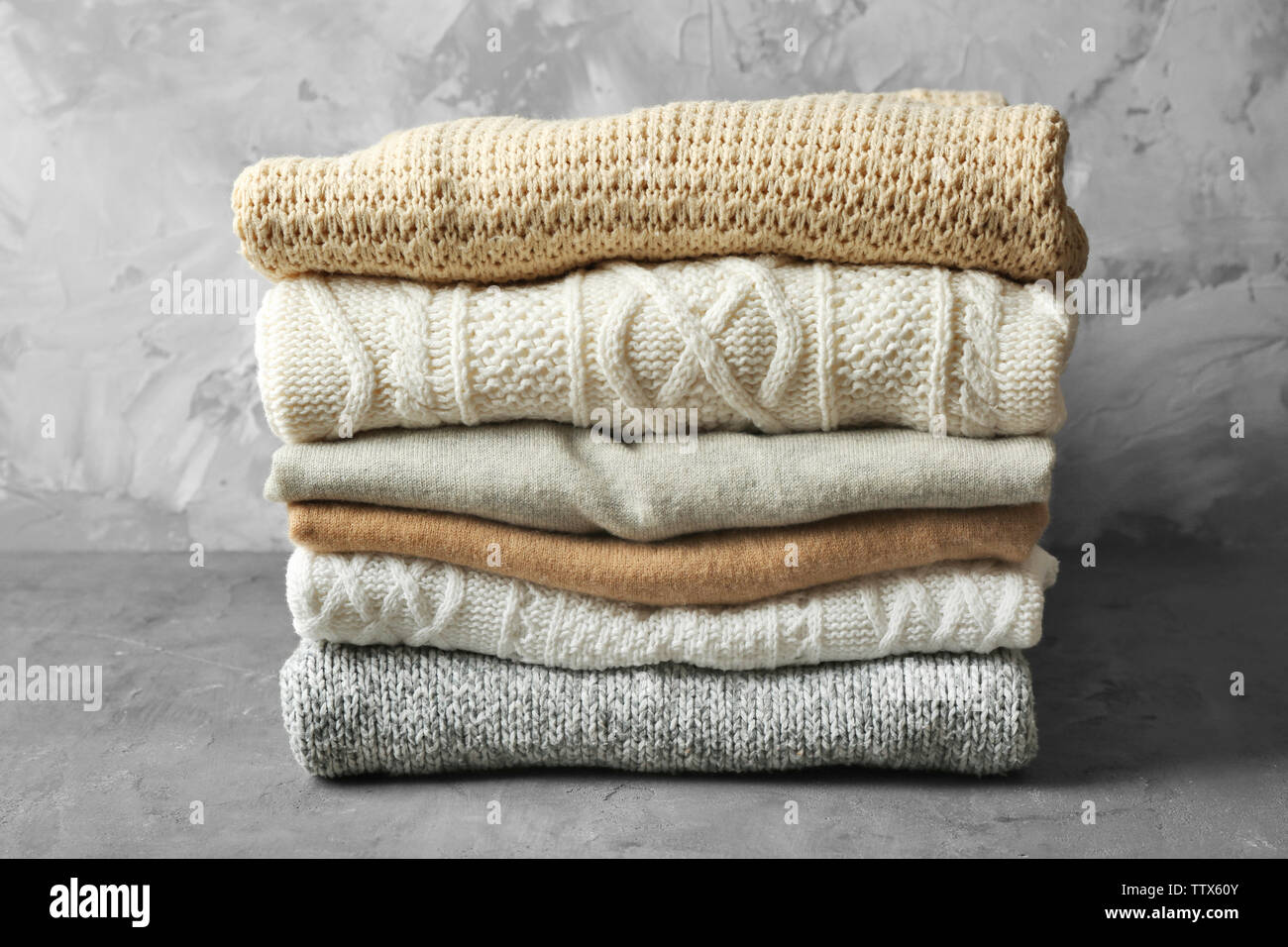 Stack of folded clothes on grey background Stock Photo - Alamy