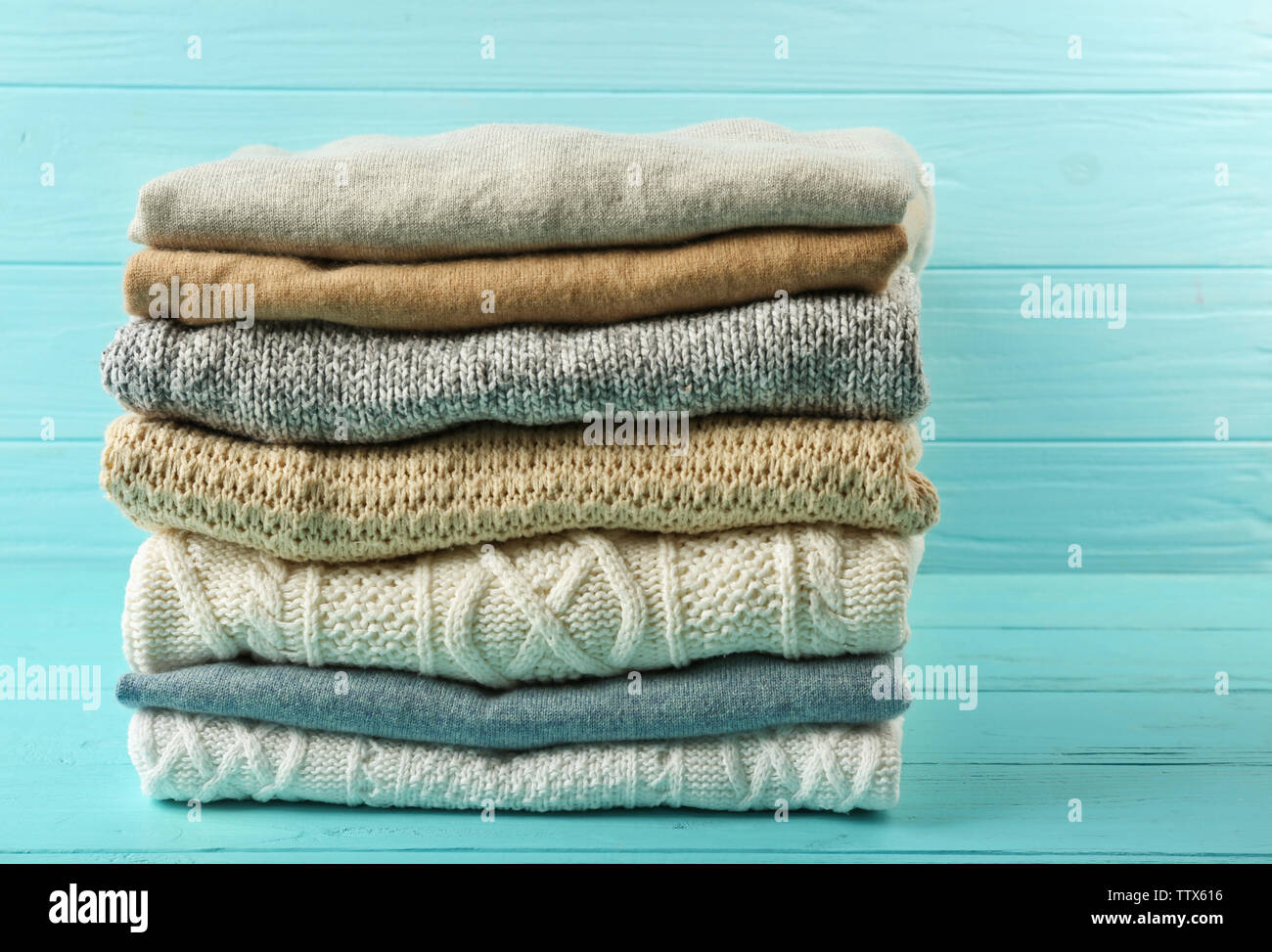 Stack of folded clothes on wooden background Stock Photo - Alamy