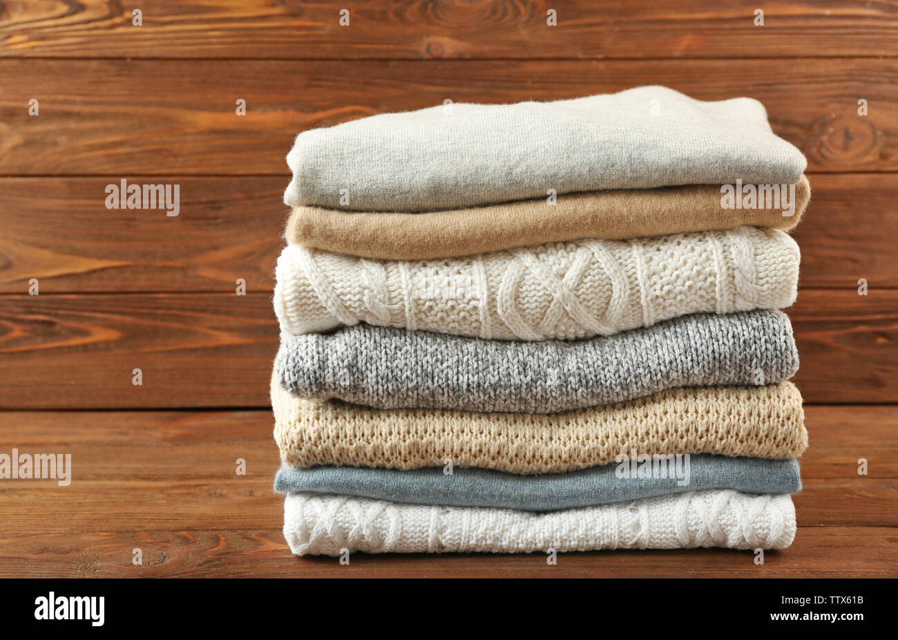 Stack of folded clothes on wooden background Stock Photo - Alamy
