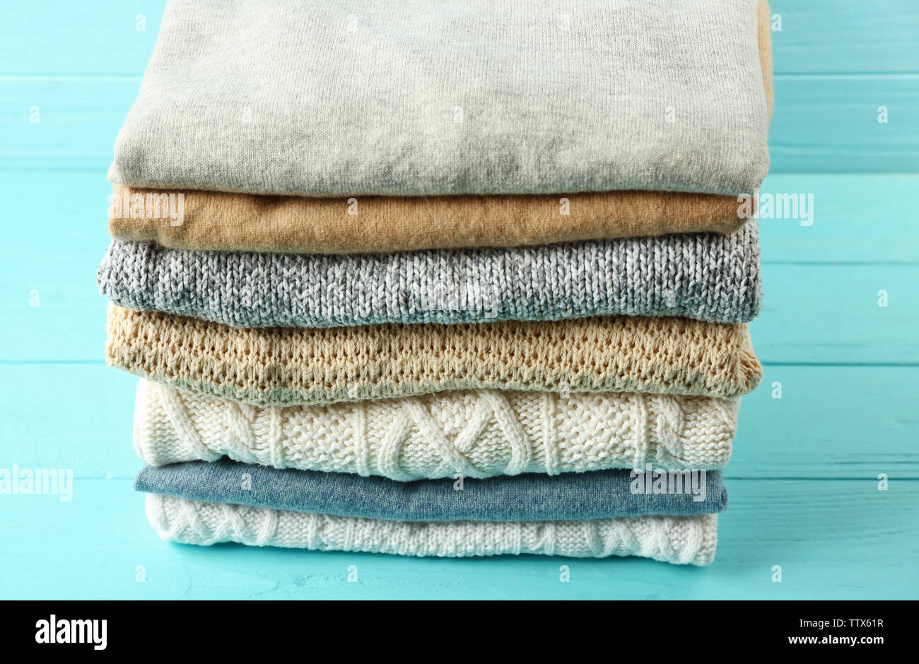 Stack of folded clothes on wooden background Stock Photo - Alamy